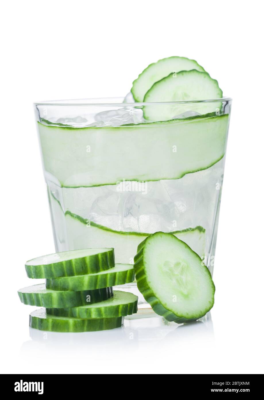 Fresh cold cucumber water with ice cubes and cucumber slices on white ...