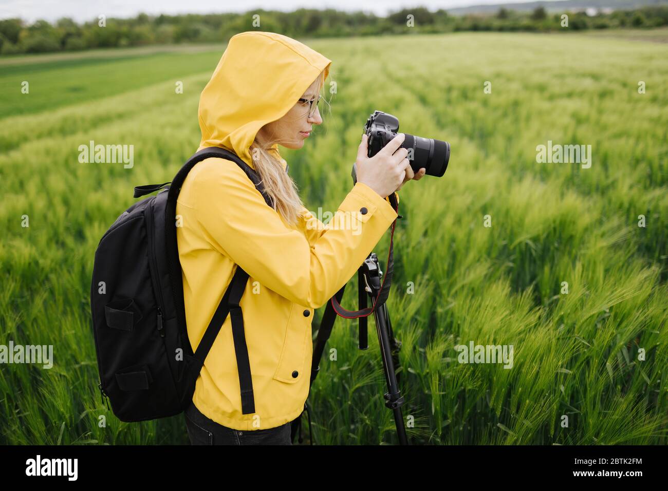 Female photographer using tripod and camera for shooting Stock Photo ...