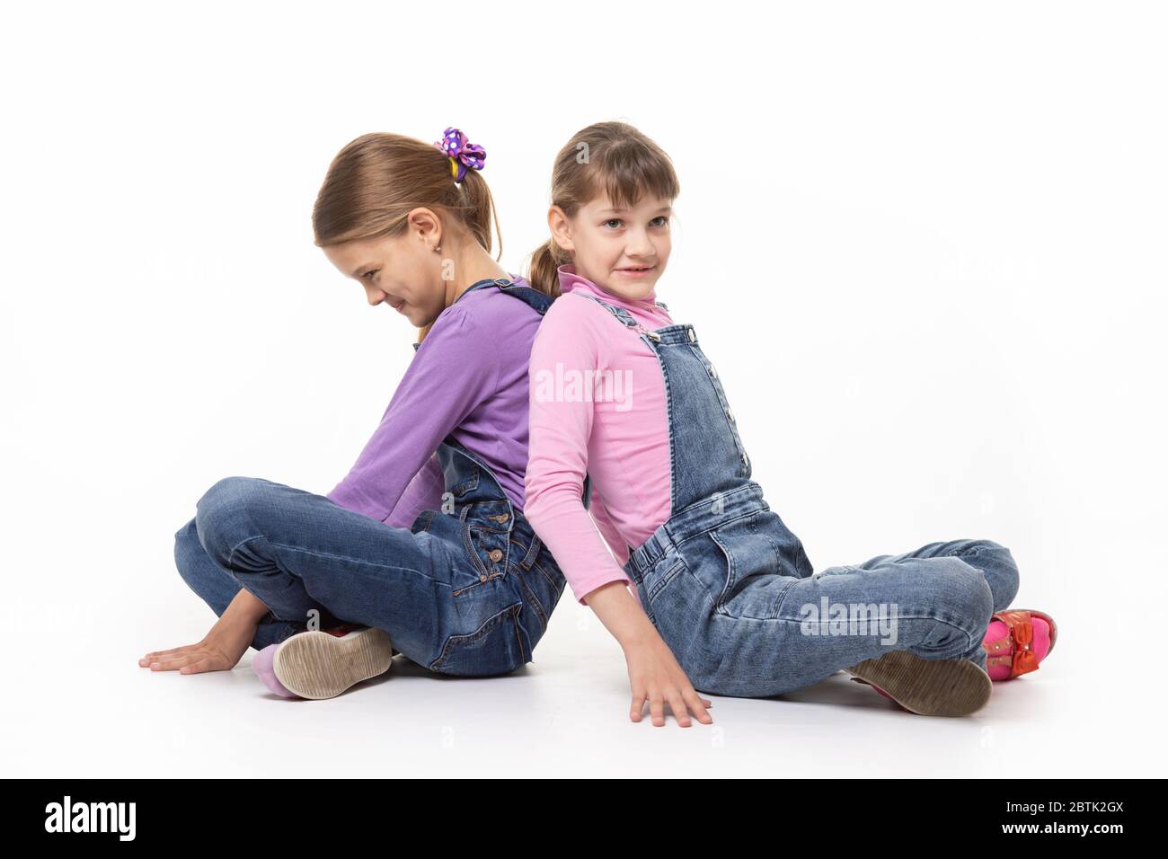 Sisters quarreling pushing each other's backs Stock Photo - Alamy