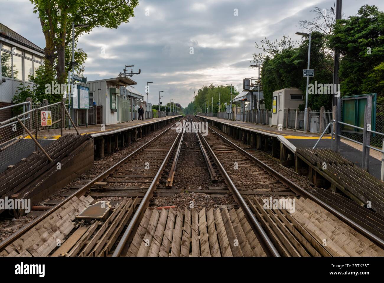 one person alone on an empty railway station platform waiting for a ...