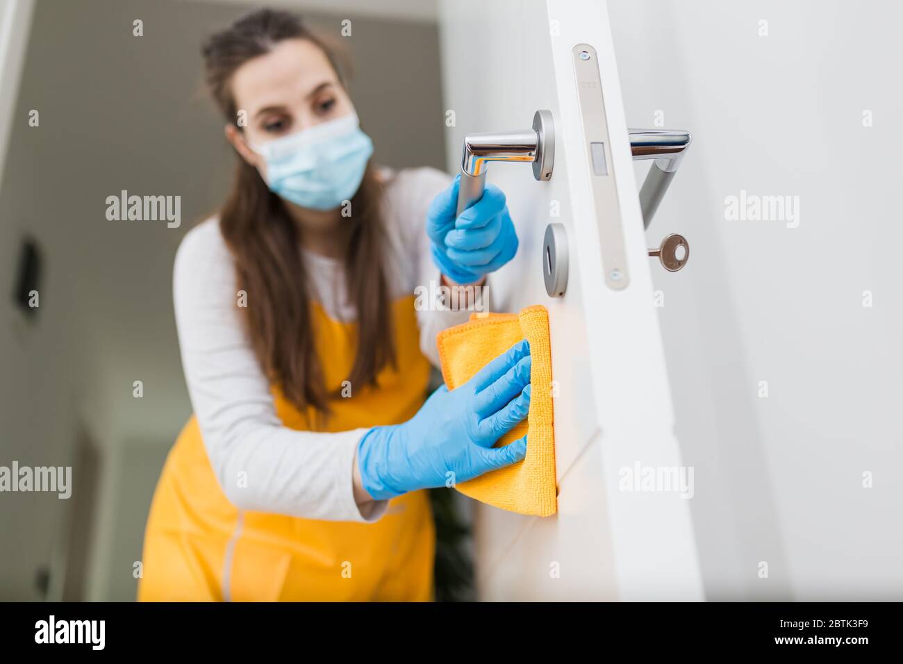 Woman housekeeper wipes the door with rag. Housekeeping concept Stock ...