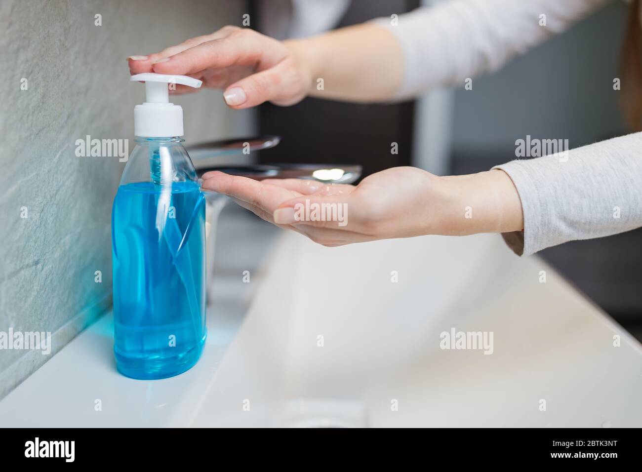 Close up of hands using liquid soap in bathroom. Washing hands hygiene ...