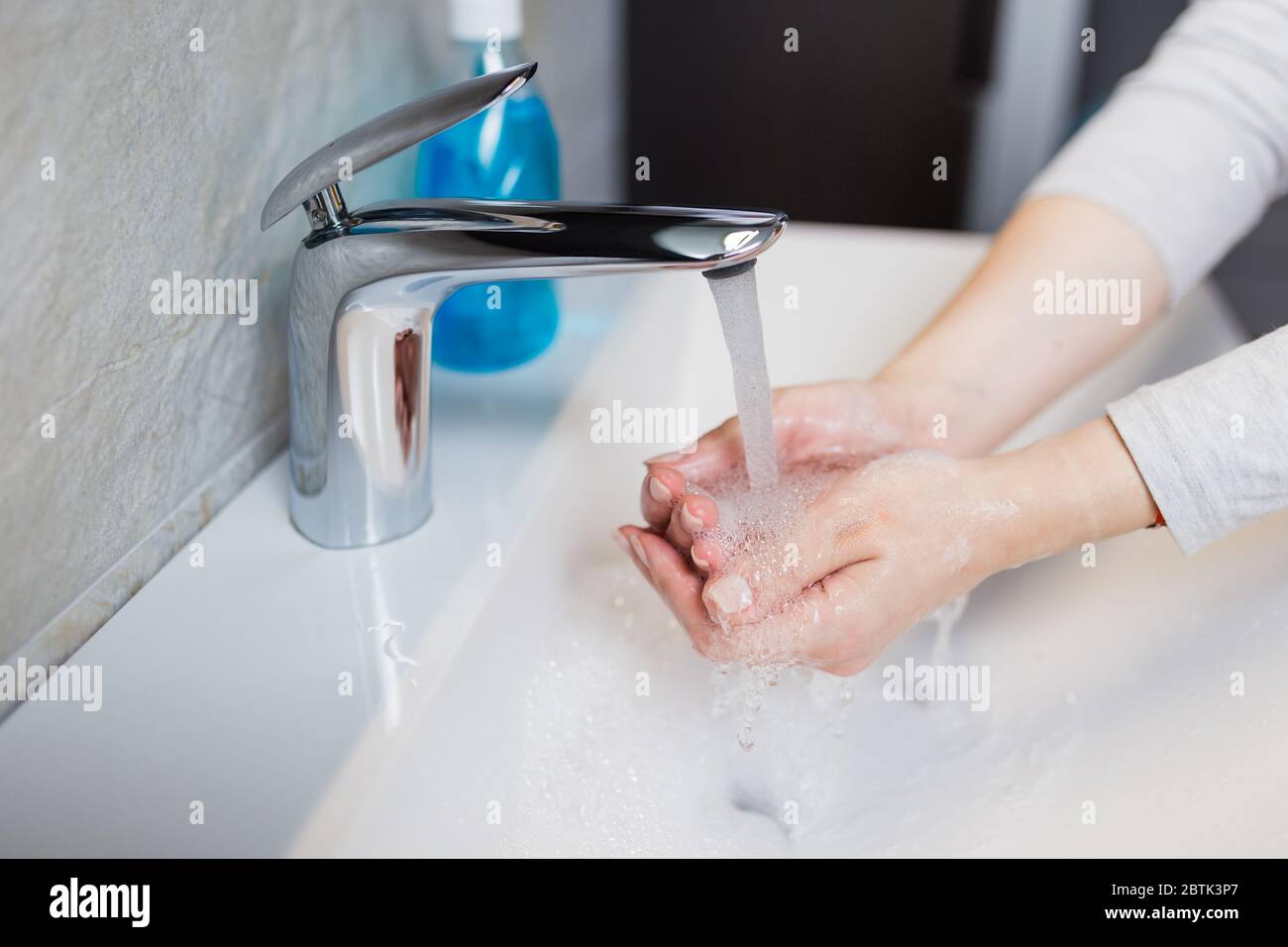Washing hands under water tap in bathroom. Hygiene concept Stock Photo ...