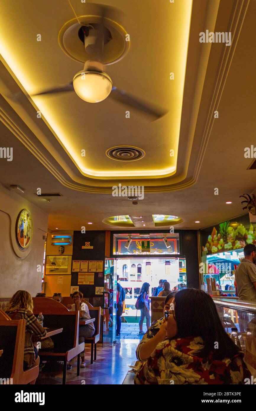 Traditional Italian cafeteria interior with tourists at the tables ...