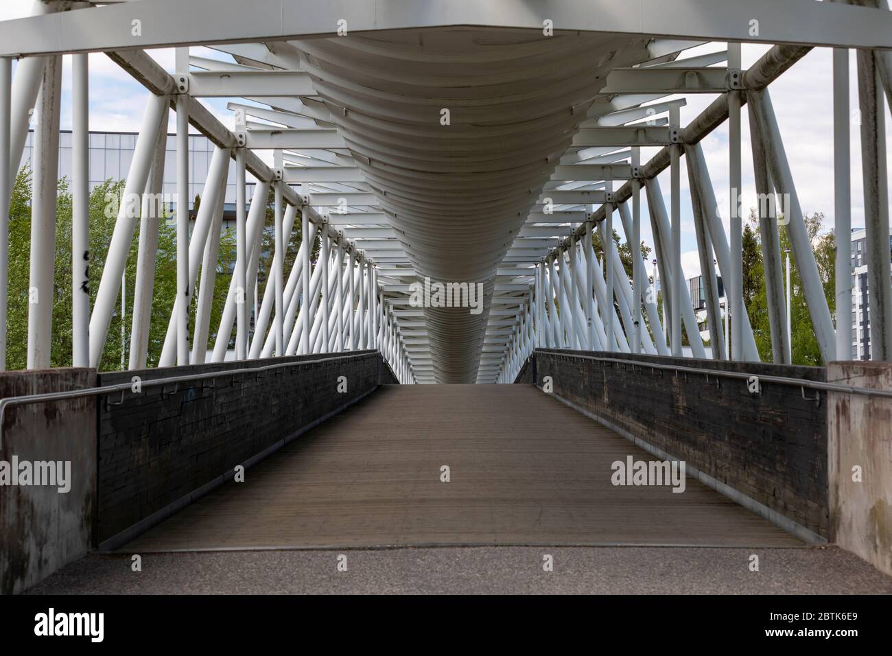 Symmetrical pedestrian bridge in Espoo with wood floor and no people in ...