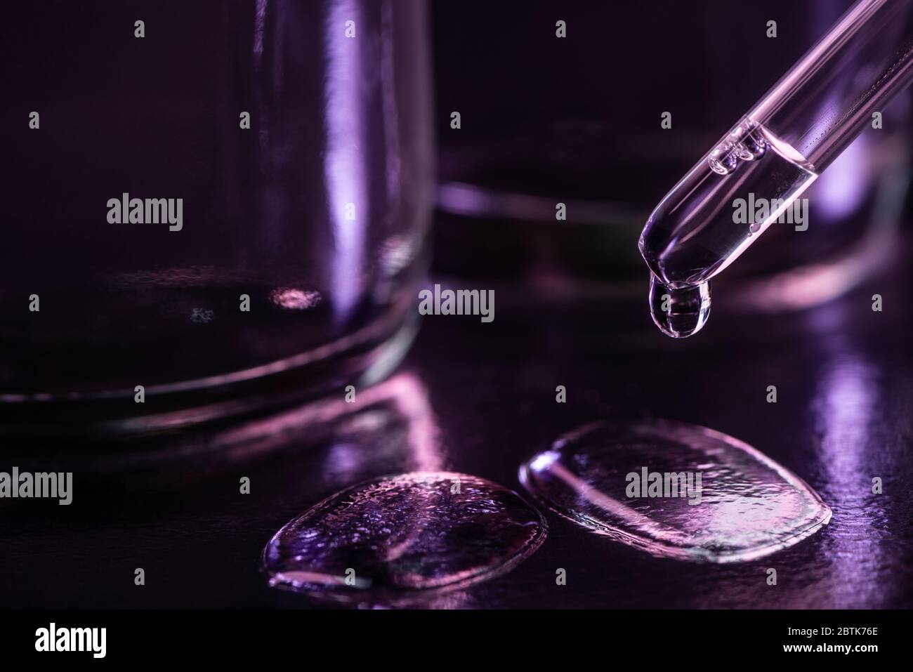 Pipette and drops falling from its tip on dark background Stock Photo ...