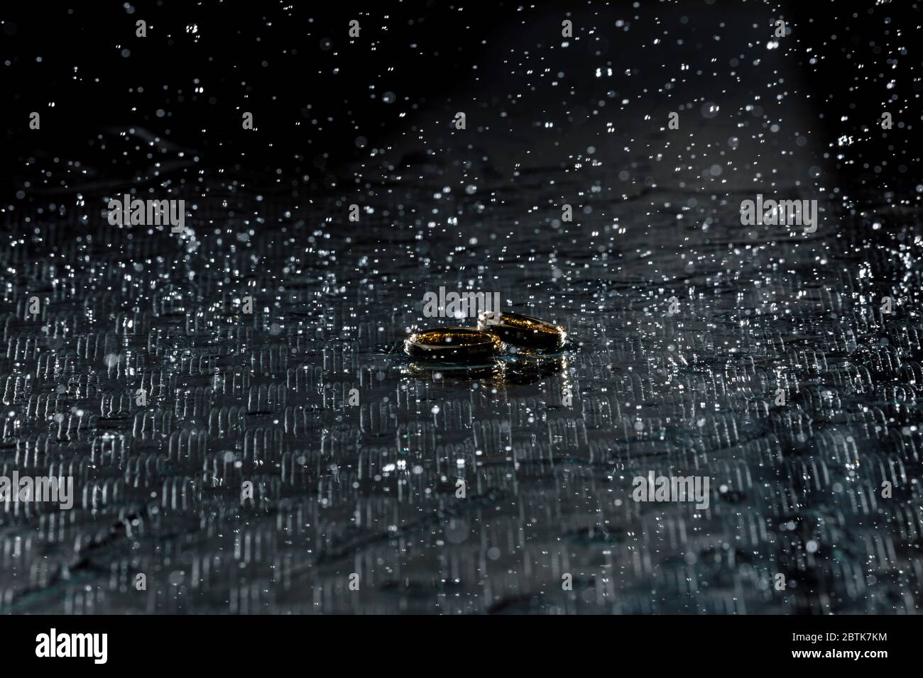 Wedding rings and water. blue background, golden. Gold wedding rings on ...