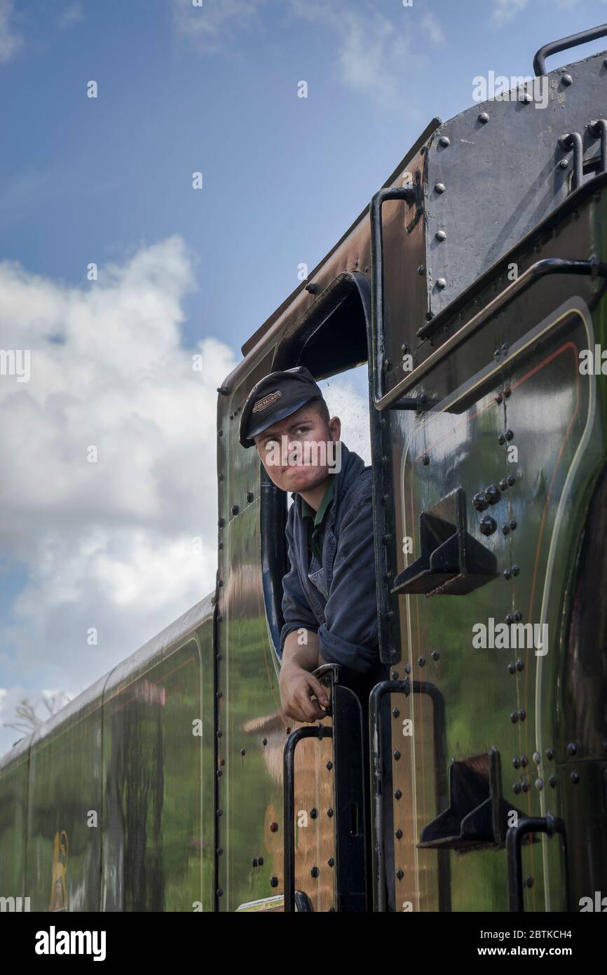Close up of isolated steam train driver awaiting departure in vintage ...