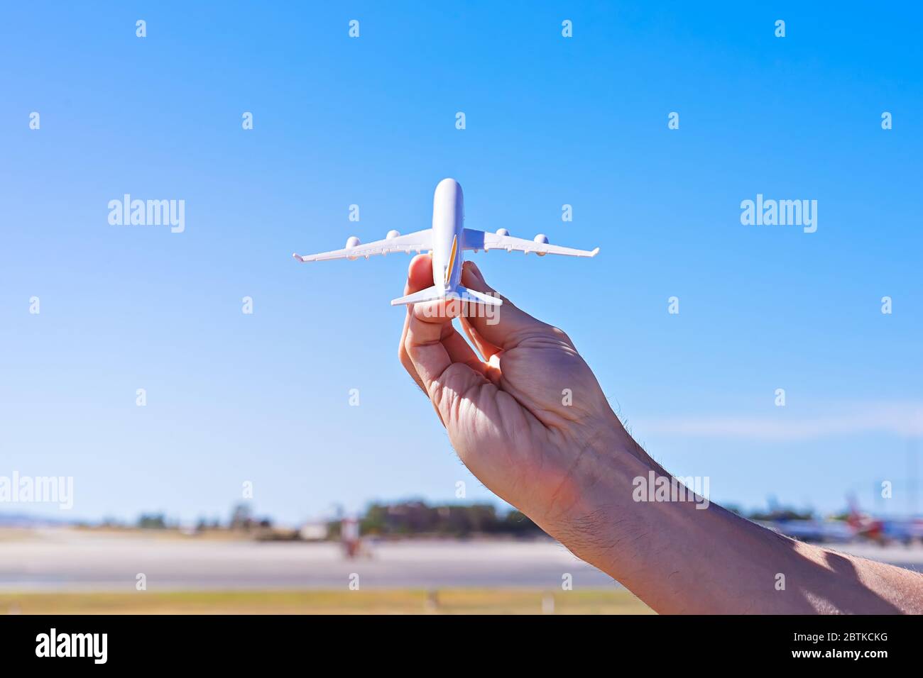 Aircraft in male hand against landscape of airport. Ban of flights is ...