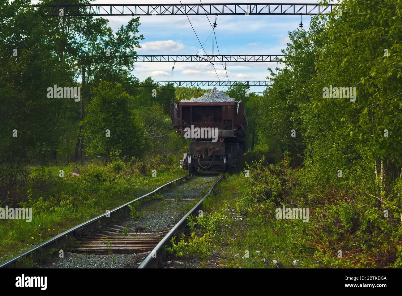The freight train electric locomotive moves on rails in the middle of ...