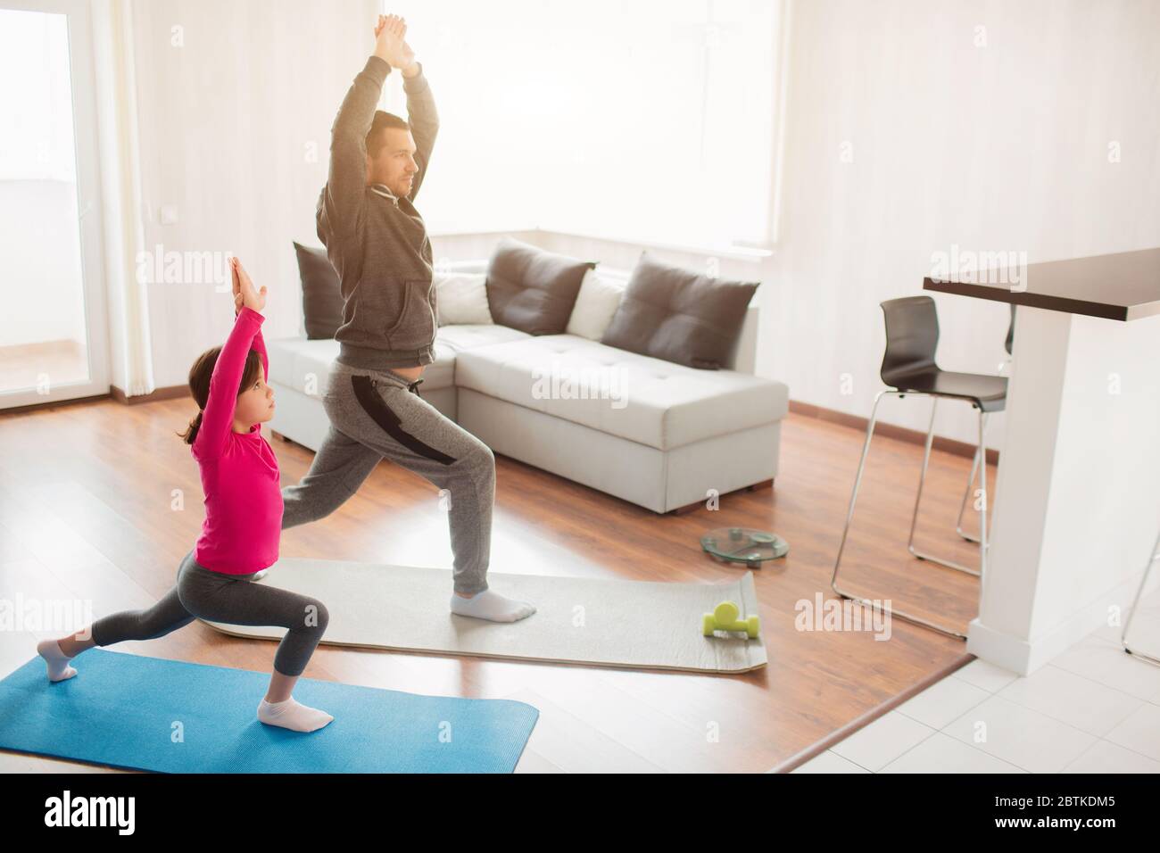 Little girl and her young father are doing lunge forward workout at ...