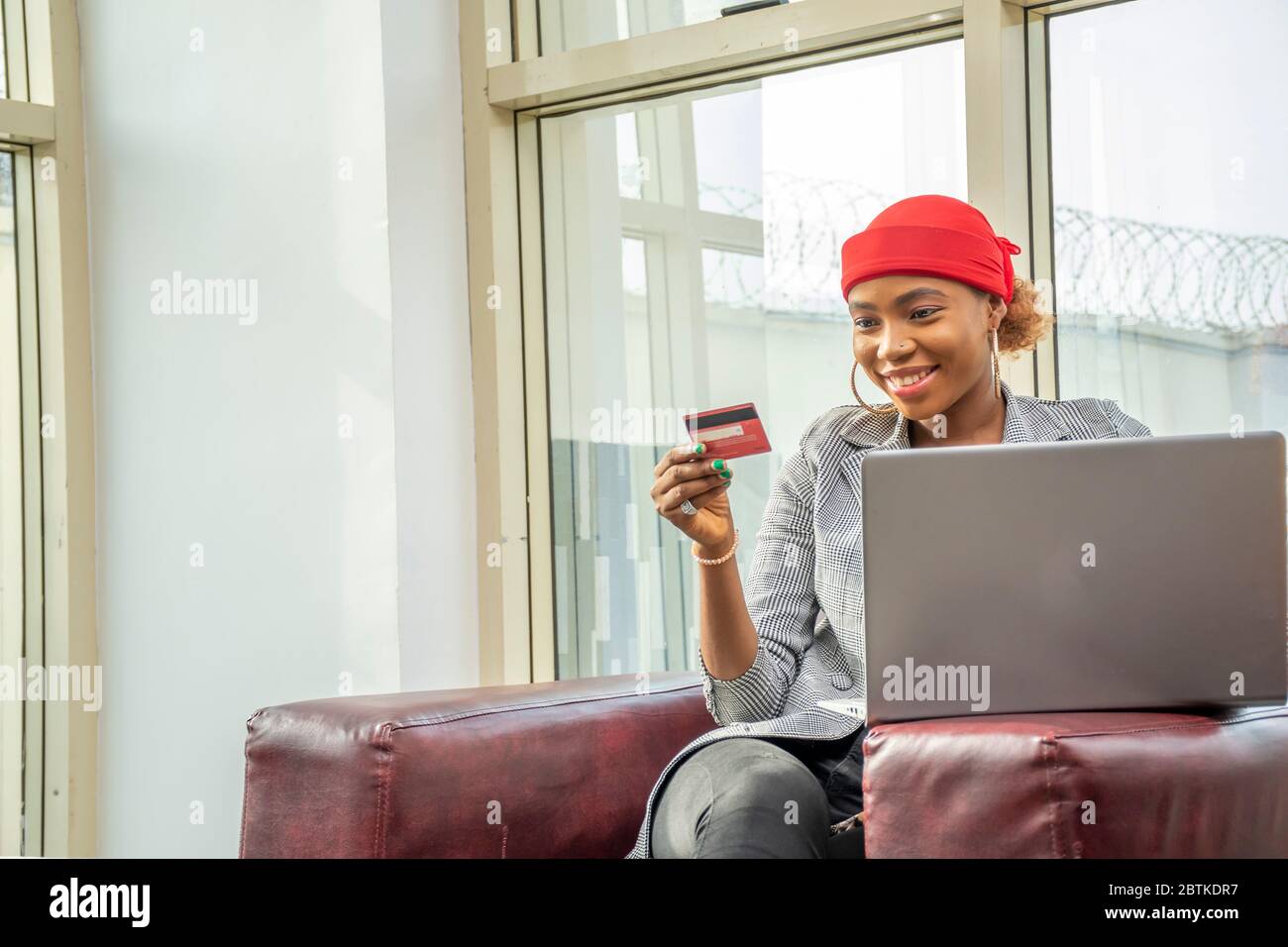 a young african business woman using his credit card and laptop ...
