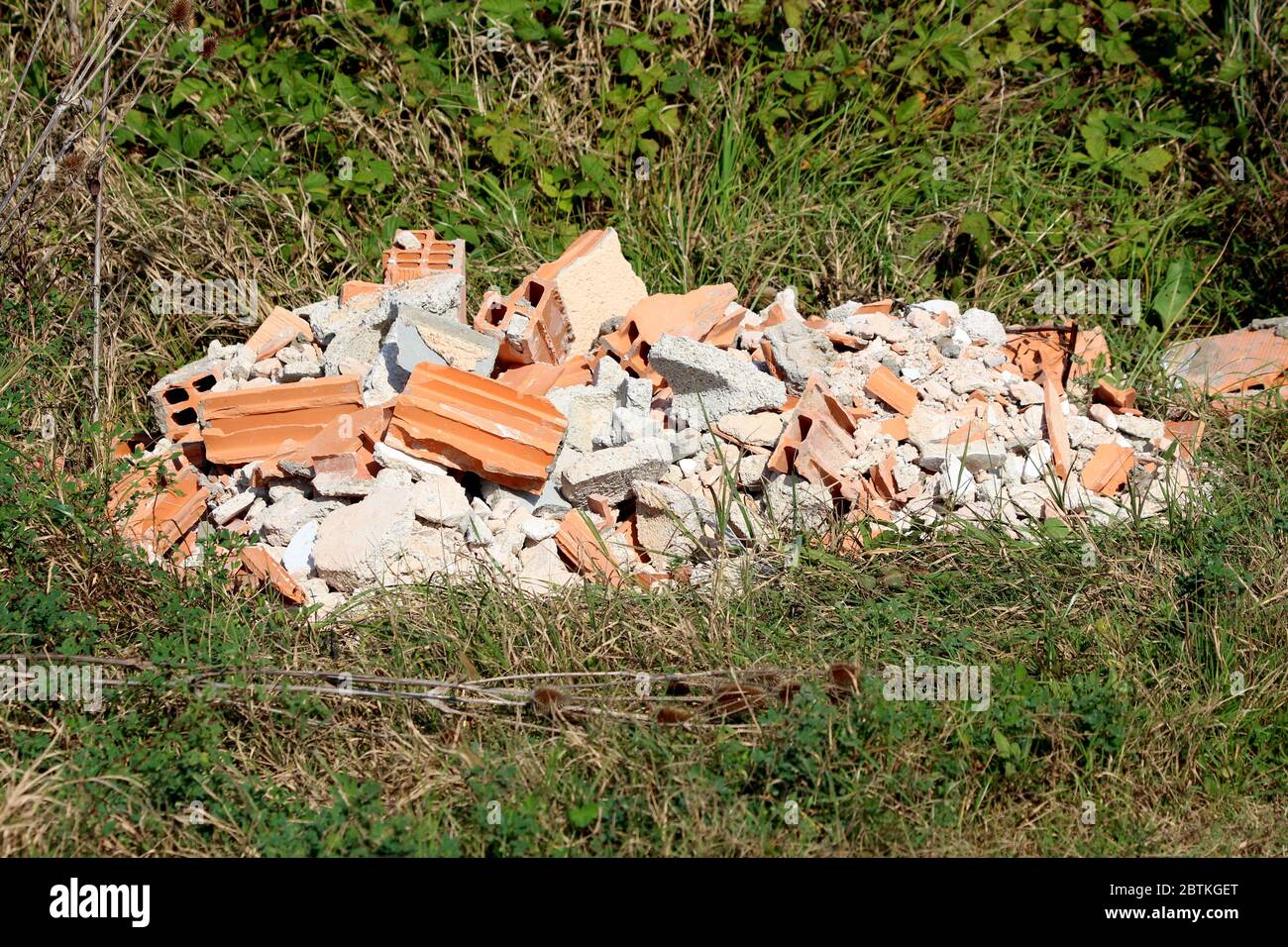 Pile of broken bricks with parts of concrete building blocks mixed with ...