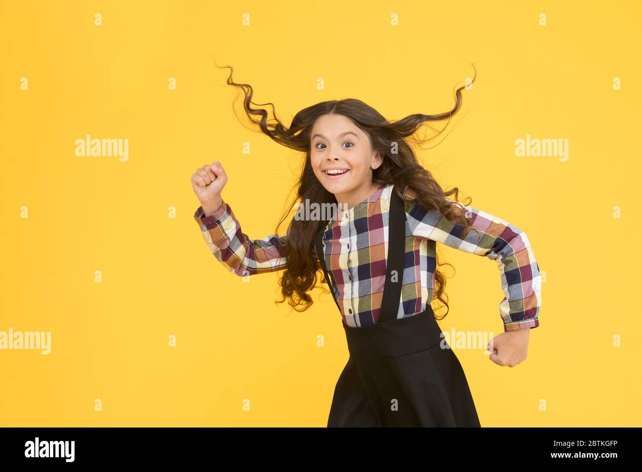 Make haste slowly. Energetic girl hurry to school. Small child wear ...