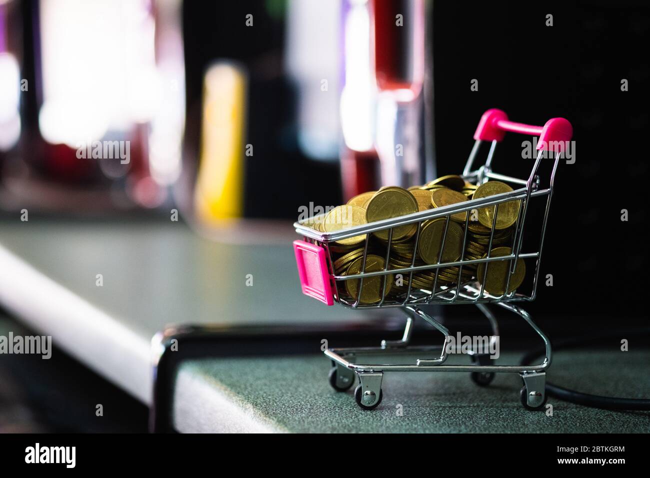 Coins in supermarket cart trolley with computer and keyboard for online ...