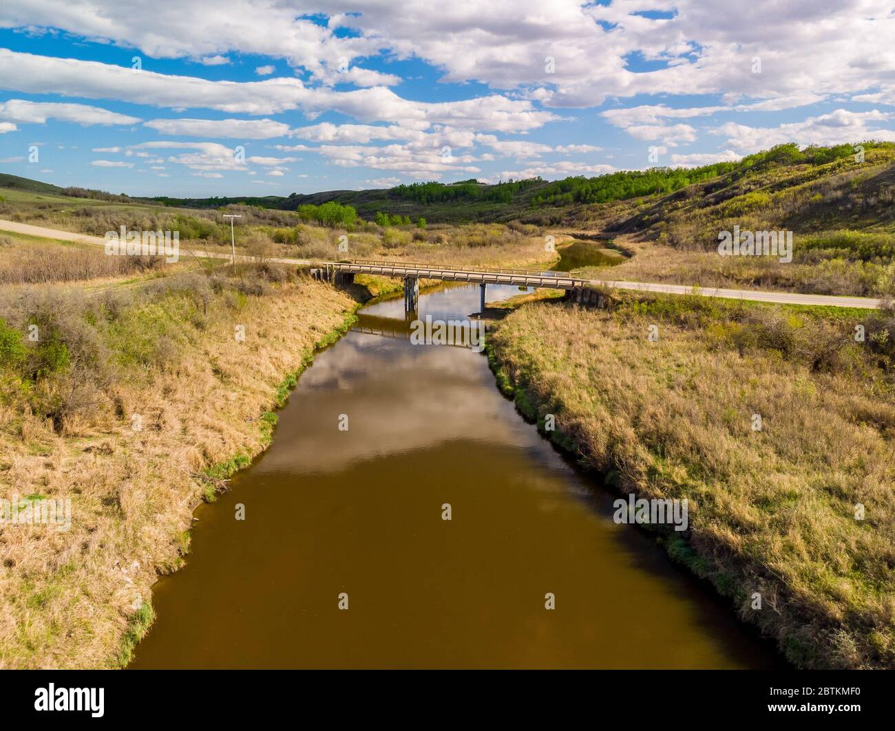 An aerial view of a old bridge over calm stream running through a ...