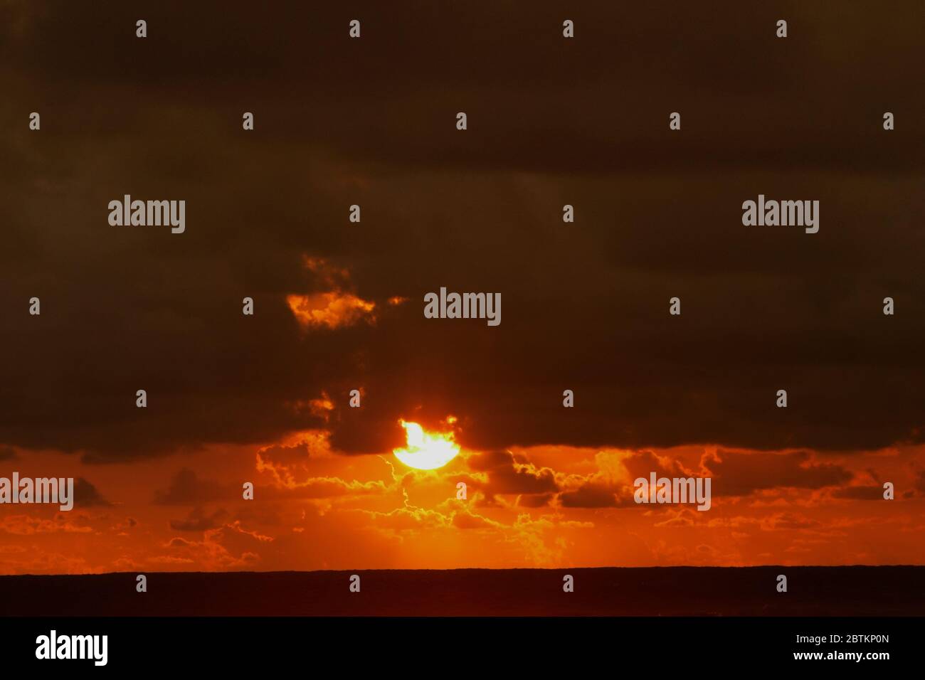 Rain clouds hid the sun before sunset on Indian Ocean, seen from ...