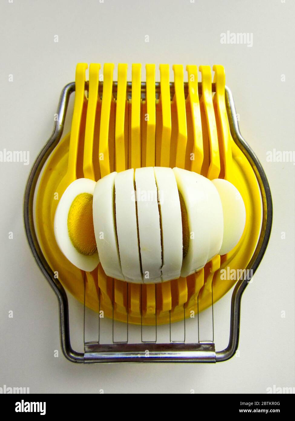 Hard-Boiled Egg in A Yellow Egg Slicer Stock Photo - Alamy