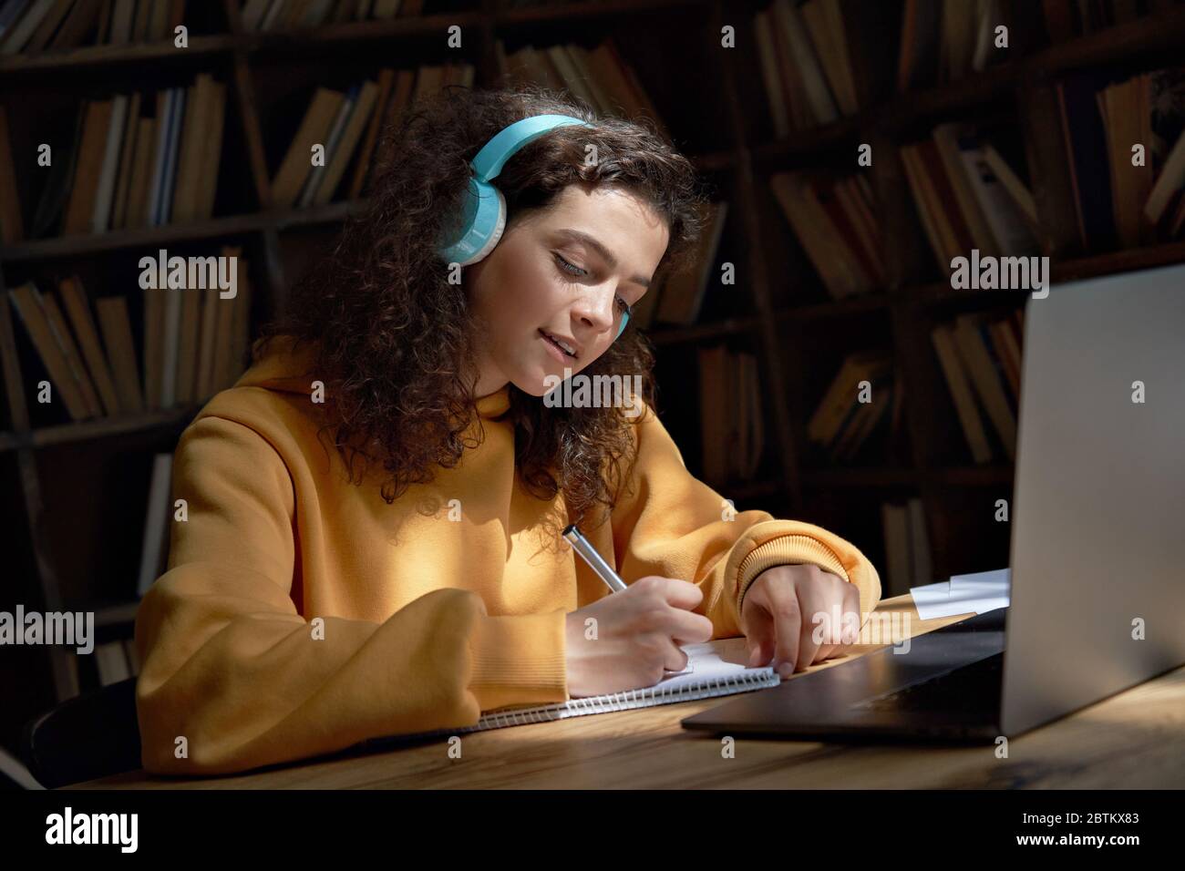 Hispanic teen girl school student wearing headphones distance elearning ...