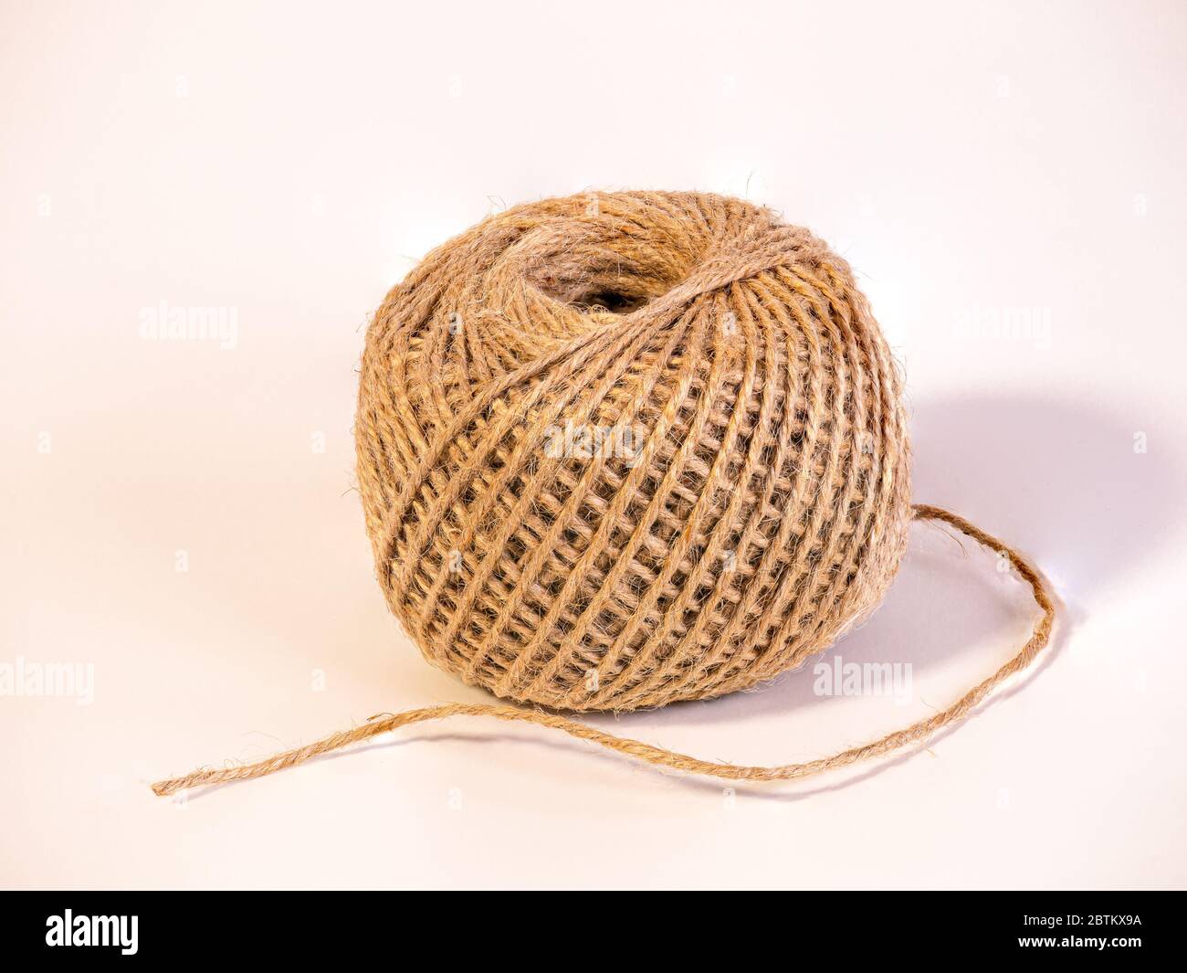 a partly uncoiled ball of string isolated on white background Stock ...