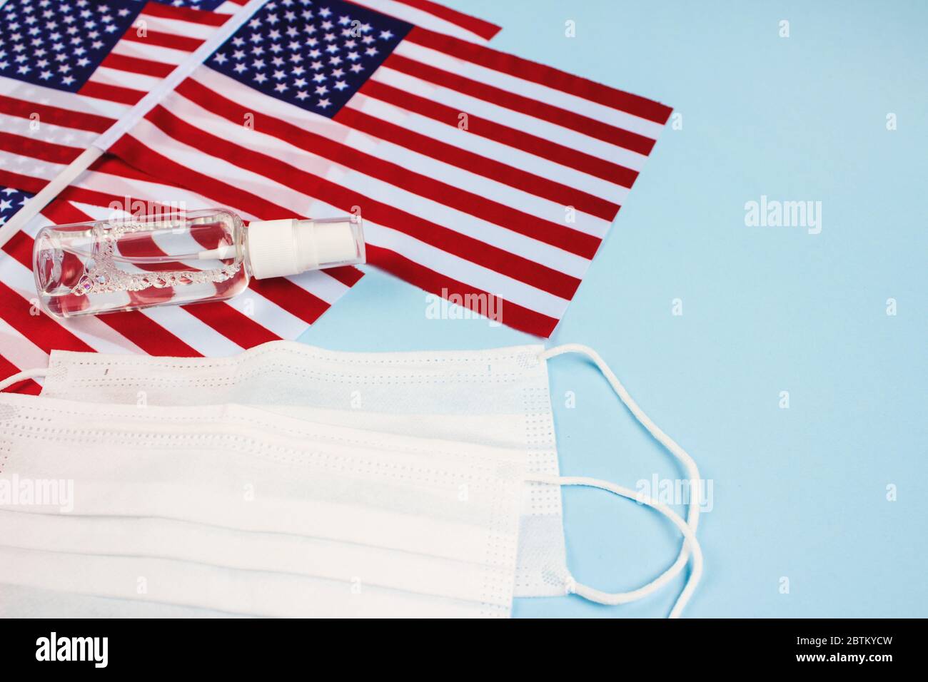 Closeup of american flags, disposable protective masks and sanitizer on ...