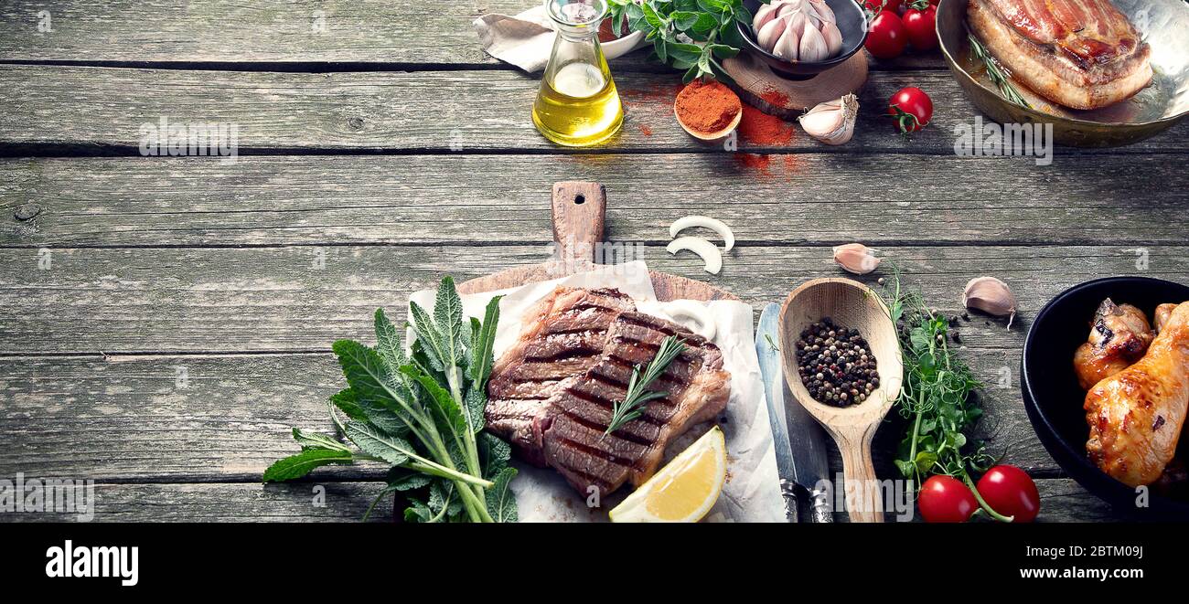 Different types of Grilled meat on rustic wooden table. Top view with ...