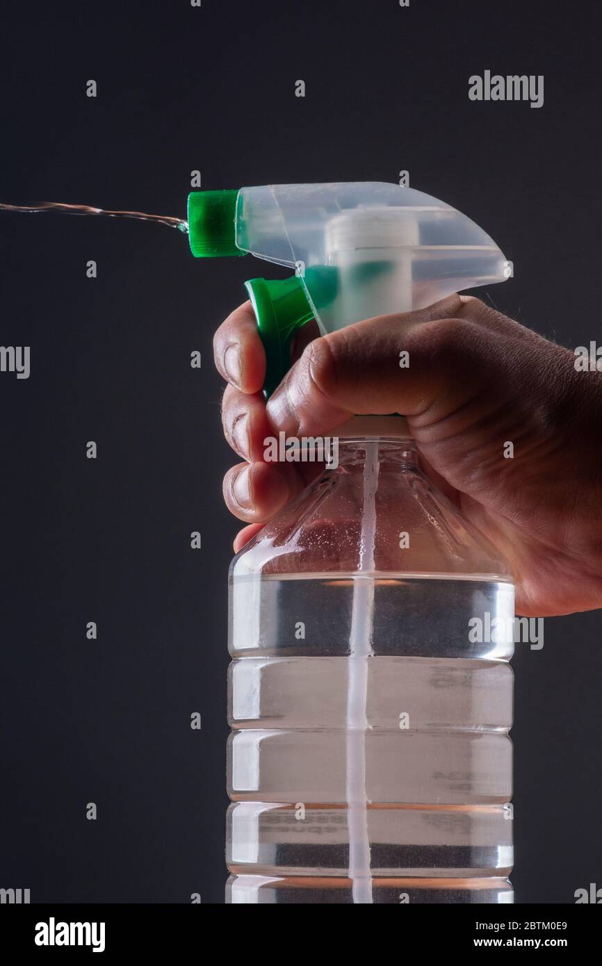 A person's hand handling a liquid alcohol dispenser Stock Photo - Alamy