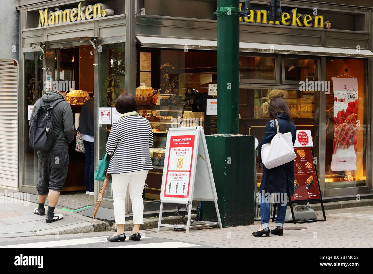 Customers wait in line outside a Belgian waffle store in Ginza during ...