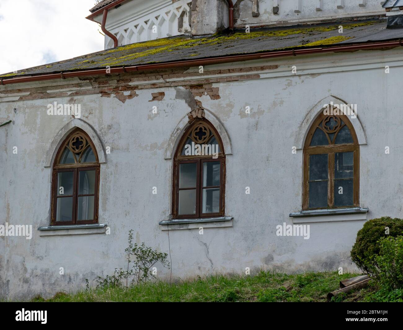 a photograph with arched windows on a white church wall Stock Photo - Alamy