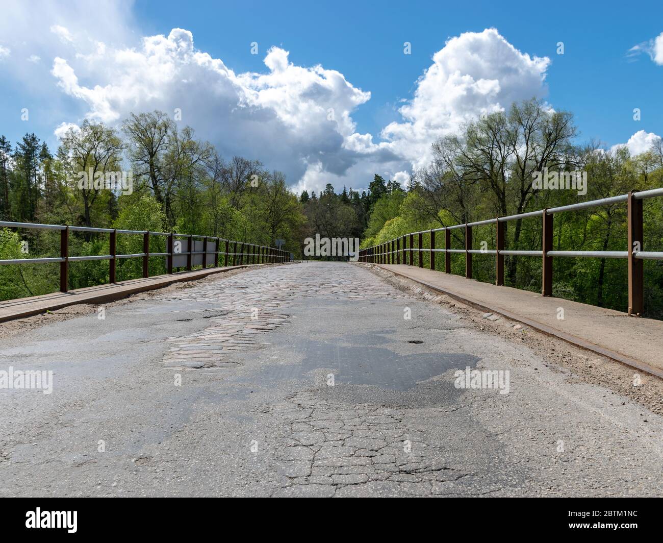 spring landscape with old bridge pavement texture, bright green trees ...