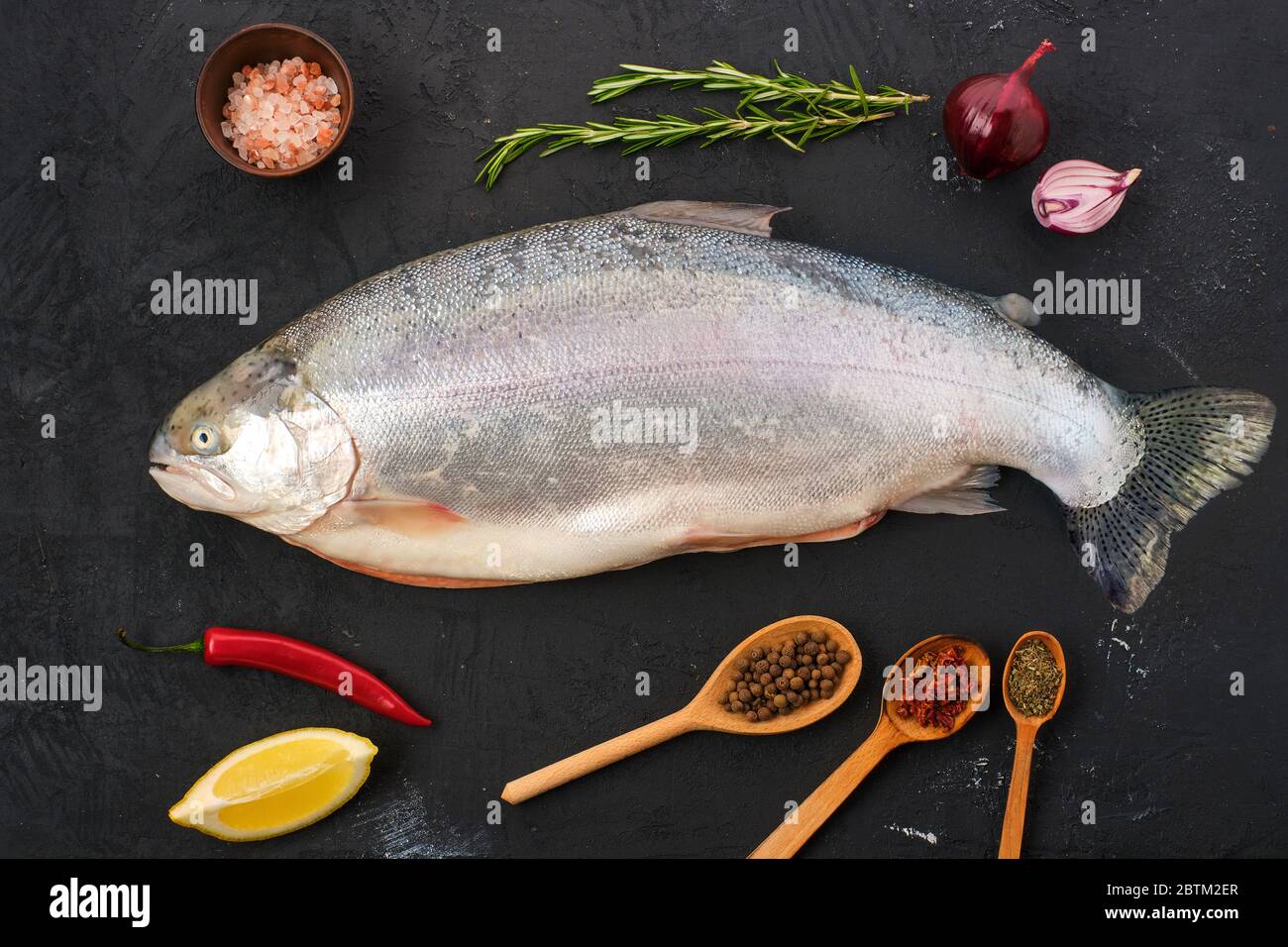 Raw tasmanian ocean trout with spice and herbs on black concrete ...