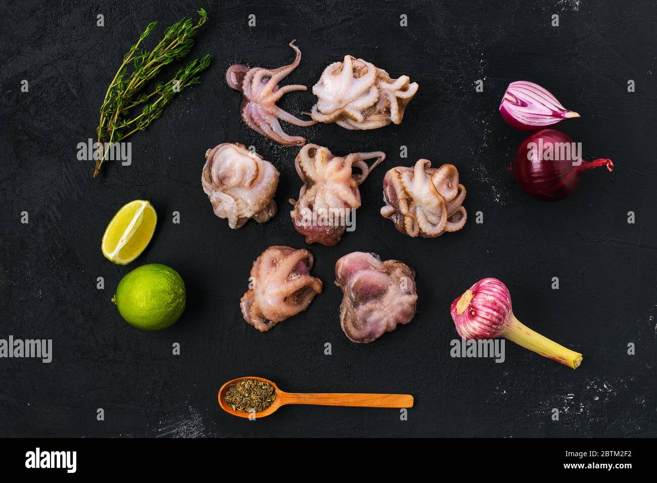 Small frozen octopus with spice and herbs on black background Stock ...