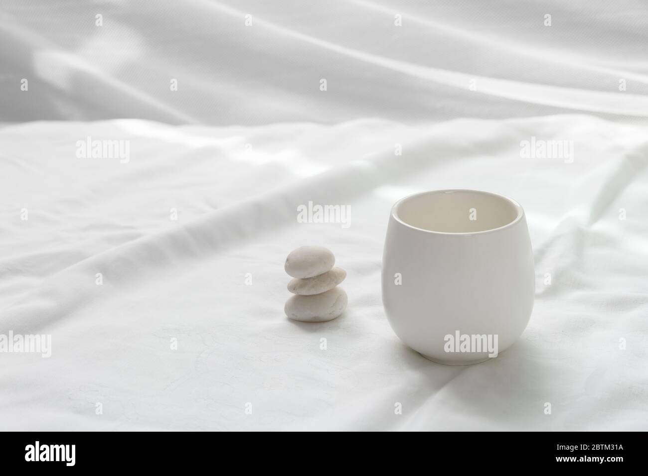clean white traditional ceramic tea drinking cup and pebble rock in ...