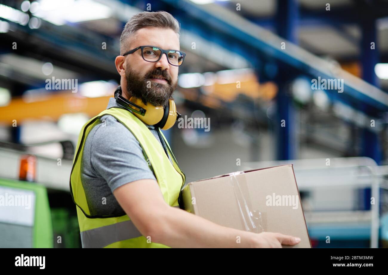 Man worker working in industrial factory or warehouse Stock Photo - Alamy