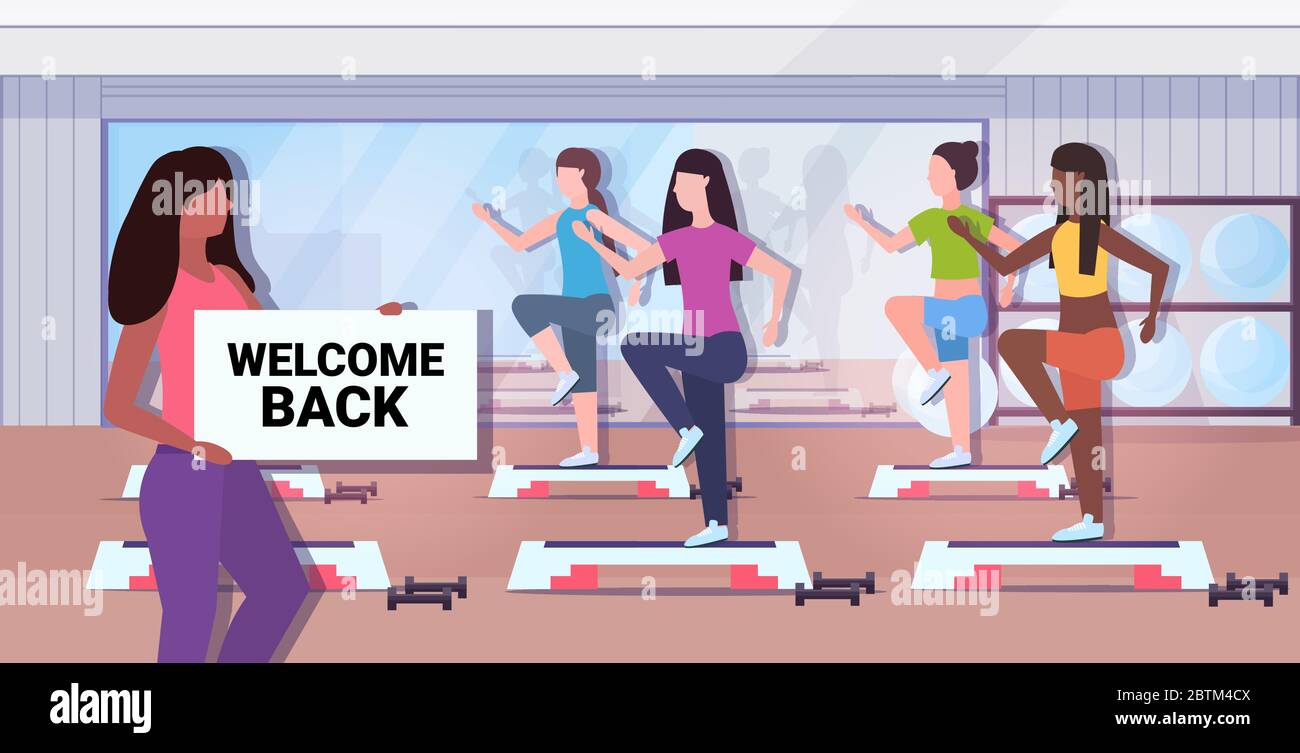 female fitness trainer holding welcome back sign board coronavirus ...