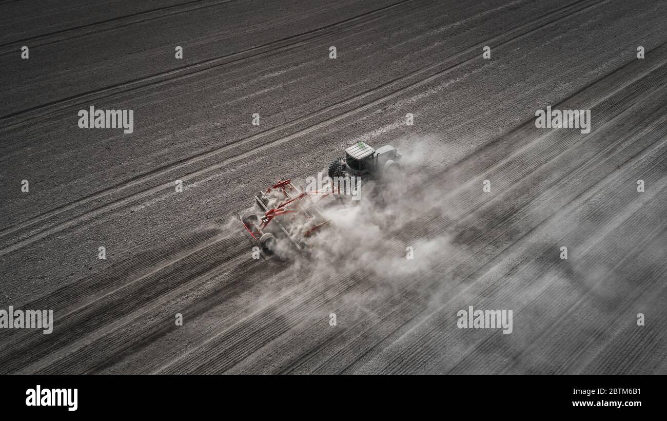 Farmers cultivating. Tractor makes vertical tillage. Aerial view Stock ...