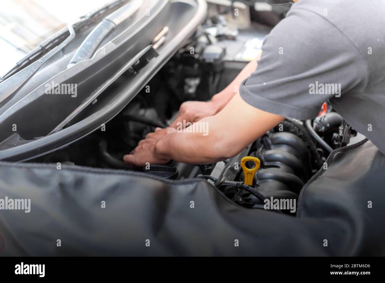 Car mechanic working on engine repair on the garage Stock Photo - Alamy