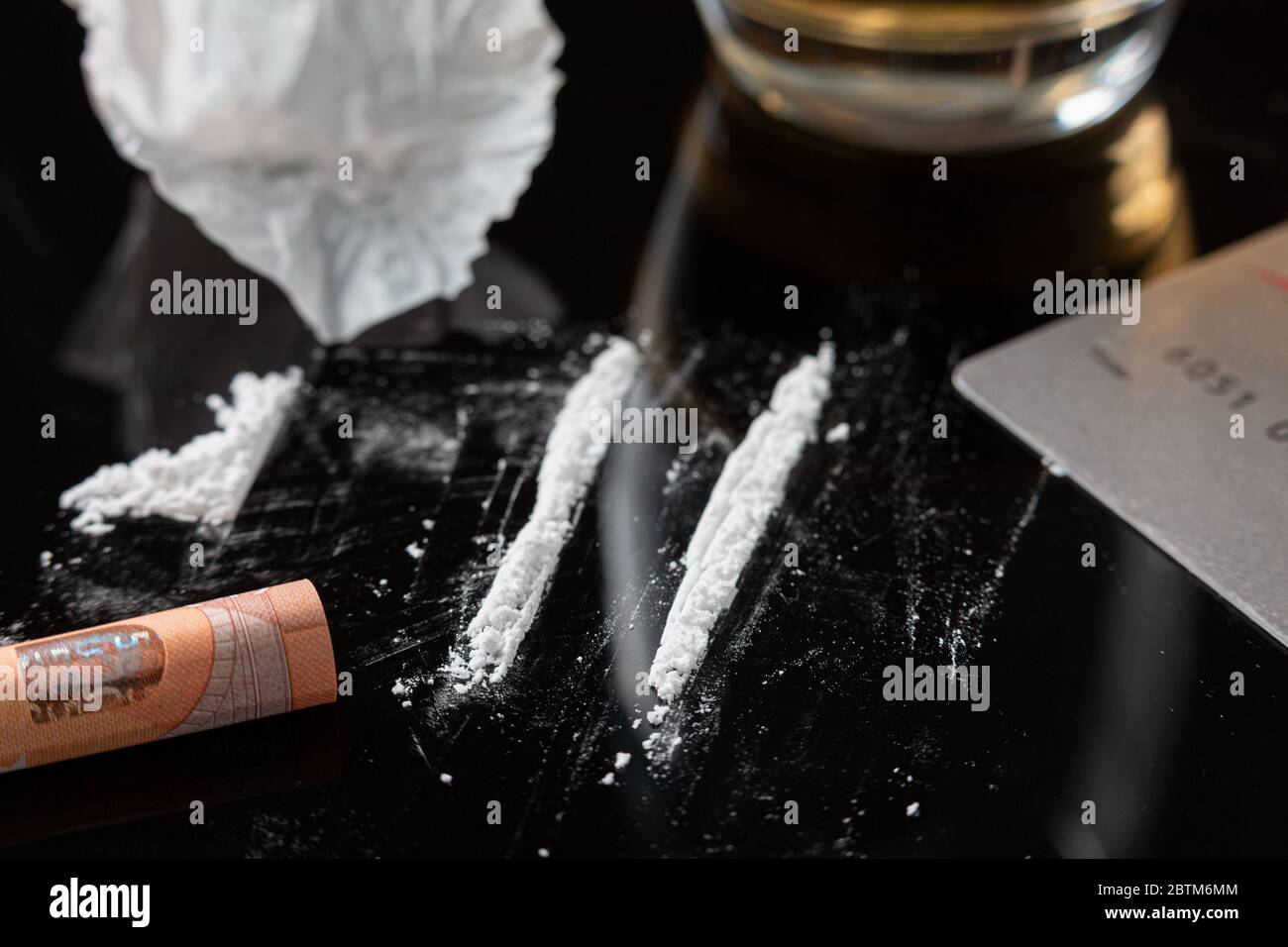 Cocaine lines prepared on a table and a rolled banknote ready to be ...