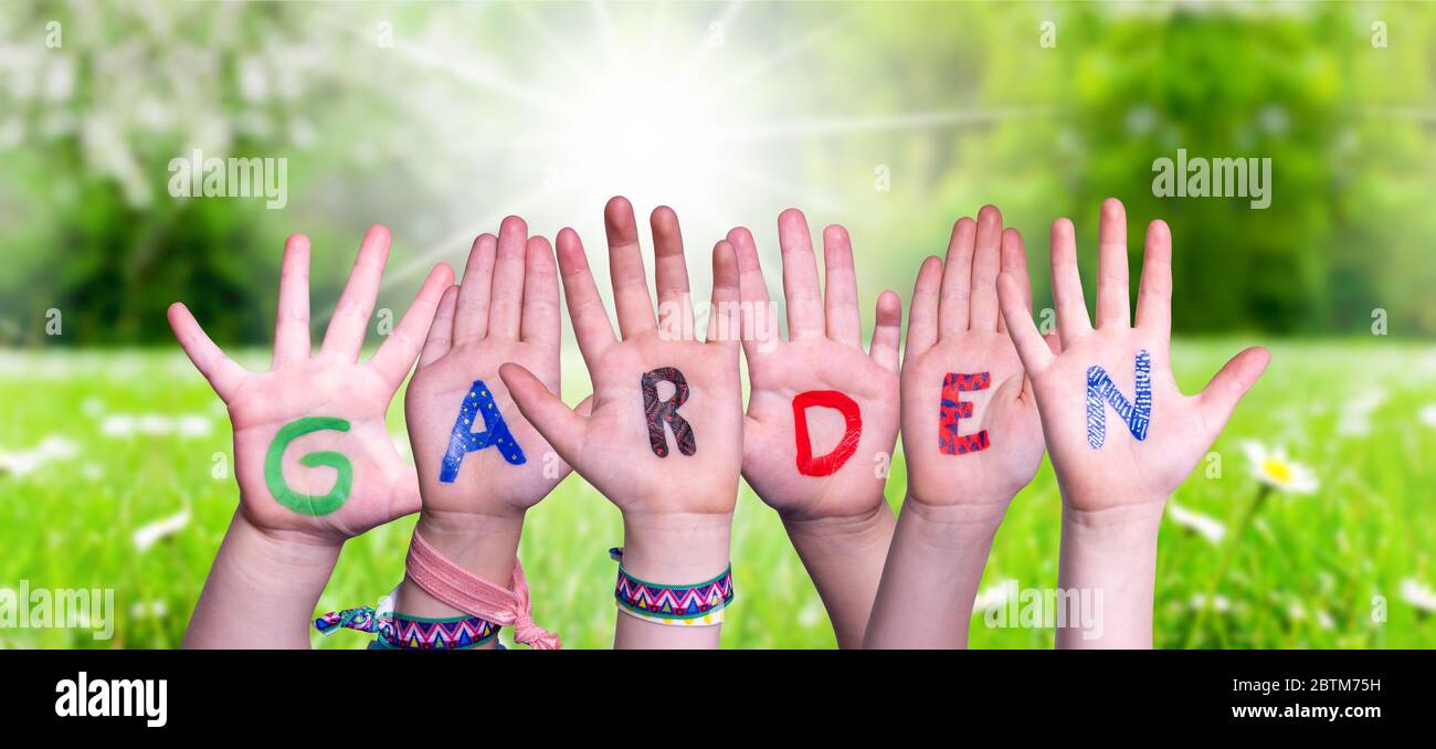 Children Hands Building Word Garden, Grass Meadow Stock Photo - Alamy