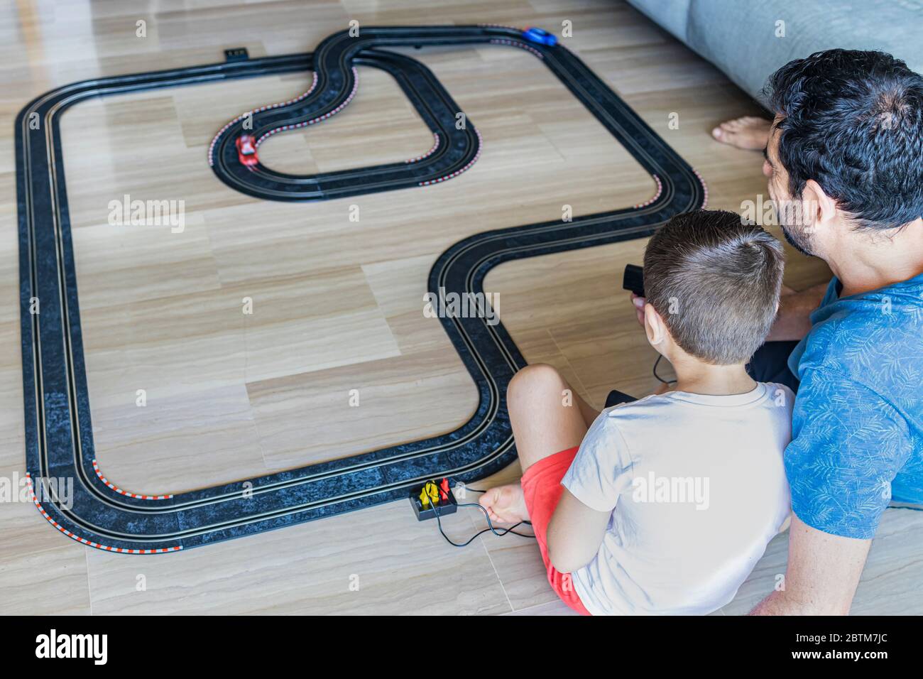 Father and son playing car races at home Stock Photo - Alamy