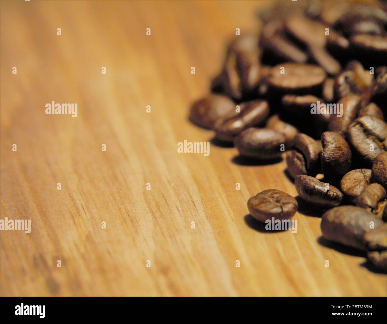 Raw coffee beans close up on a wood chopping board Stock Photo - Alamy
