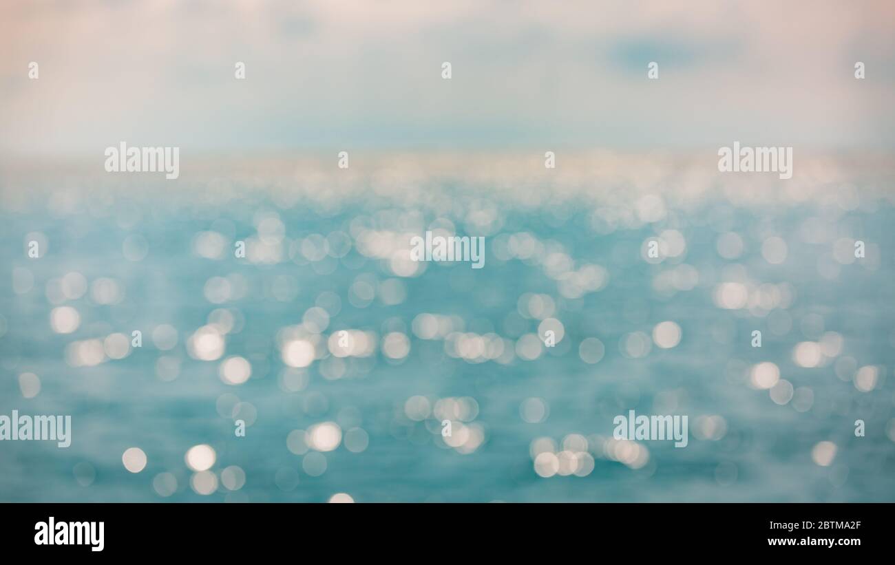 Background of blurred sunset beach and sea waves with bokeh lights ...