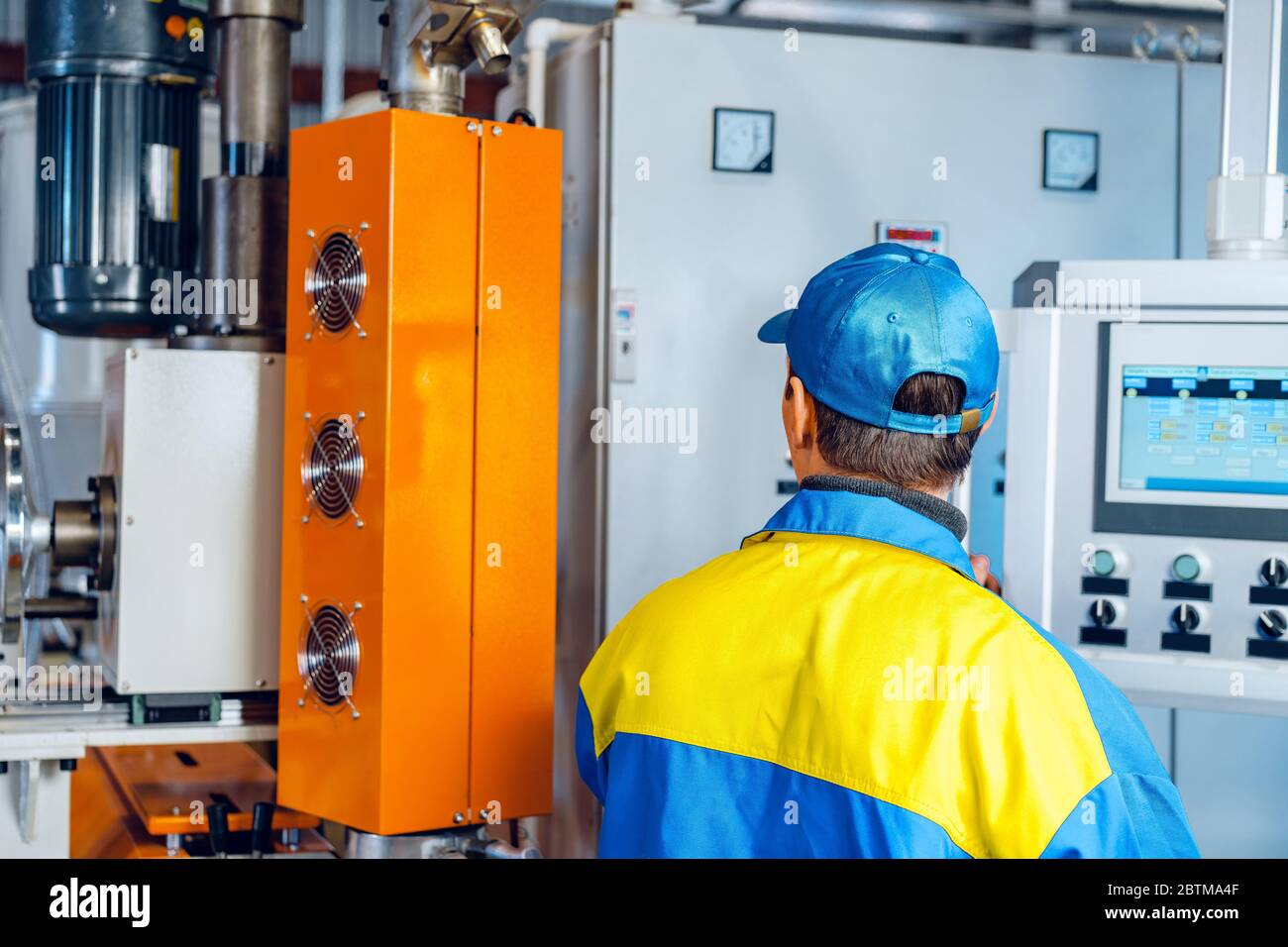 Man worker in manufacturing plant at cable factory machine control ...