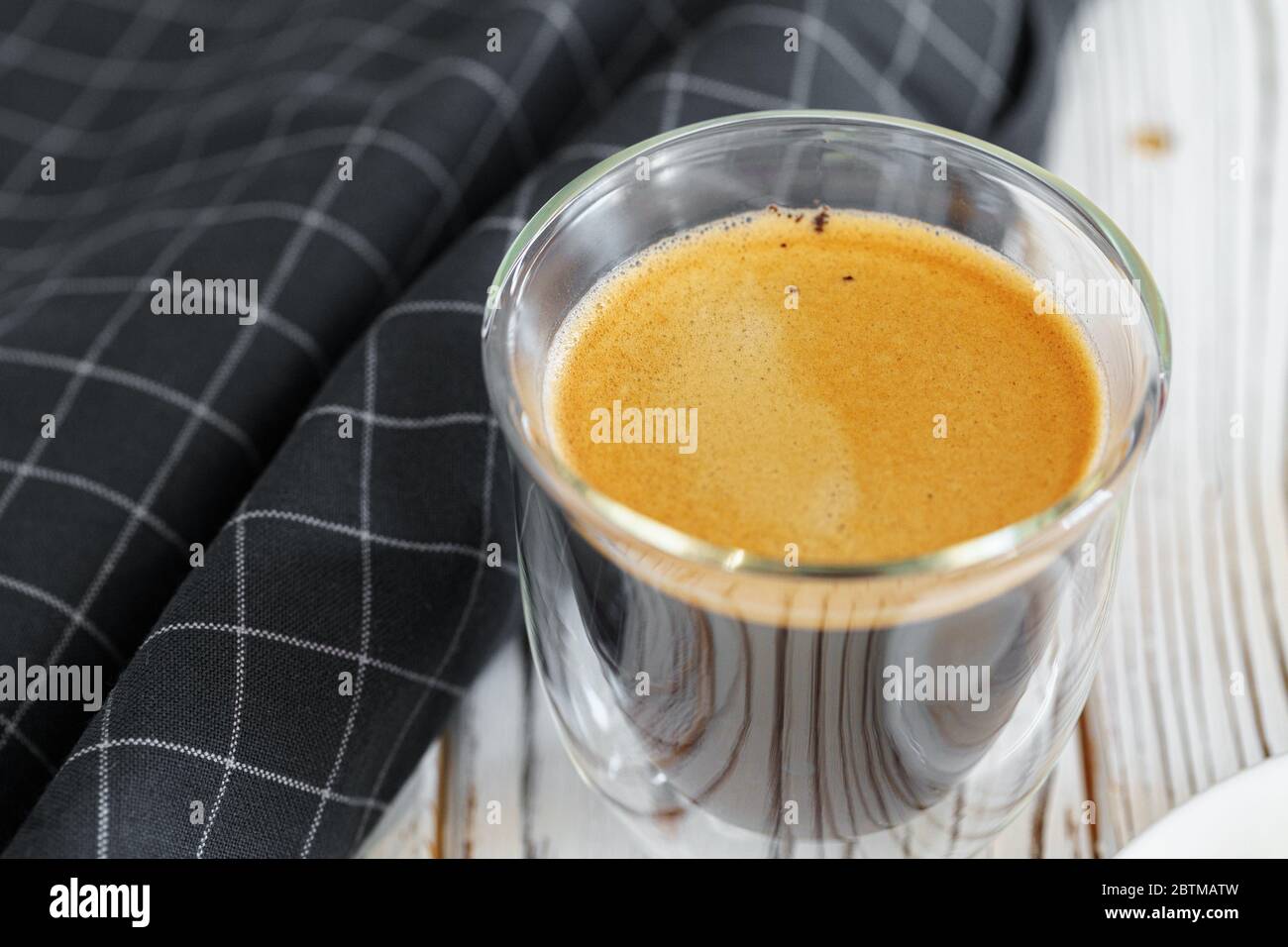 Glass cup of coffee on wooden kitchen table Stock Photo - Alamy