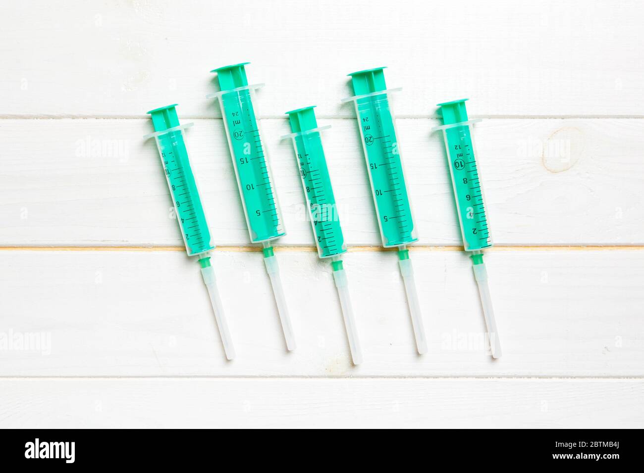 Top view of syringes of different sizes on wooden background. Medical ...