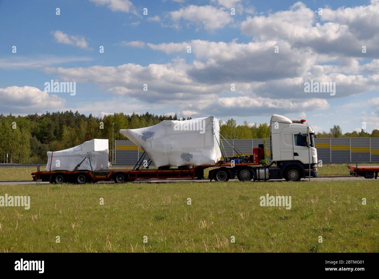 A truck with a special semi-trailer for transporting oversized loads. Oversize load or ...