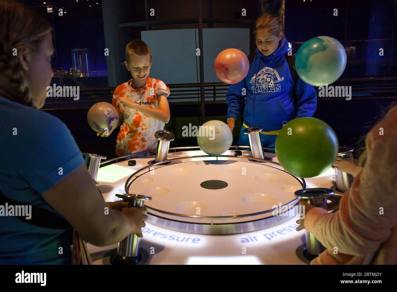 Some children enjoying with an air pressure experiment using colorful ...