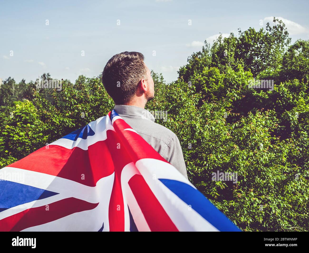 Uk flag waving blue sky hands hi-res stock photography and images - Alamy
