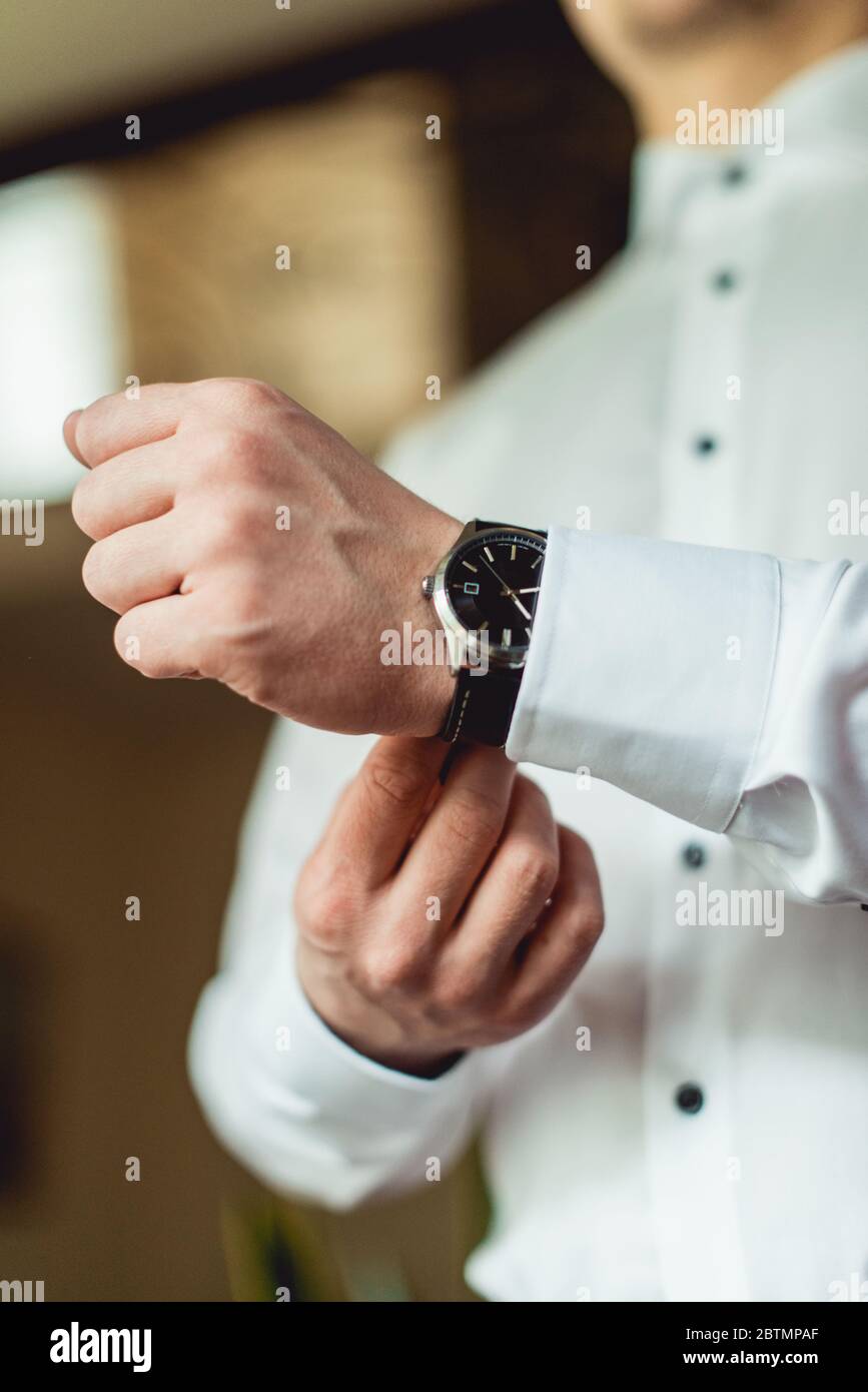 businessman checking time on his wrist watch, man putting clock on hand ...