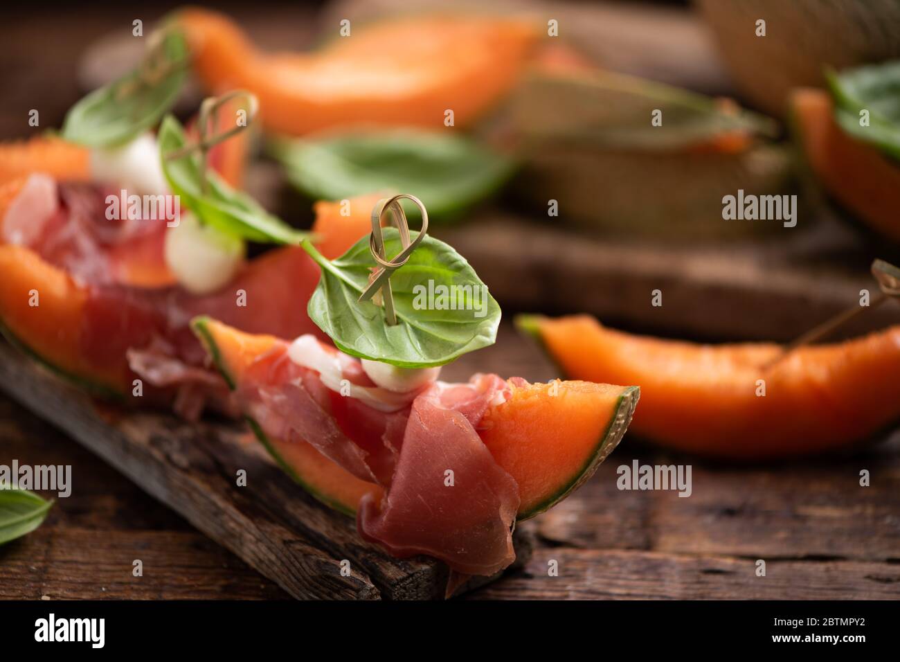 Close up of fresh water melon with parma ham, basil and cherry ...